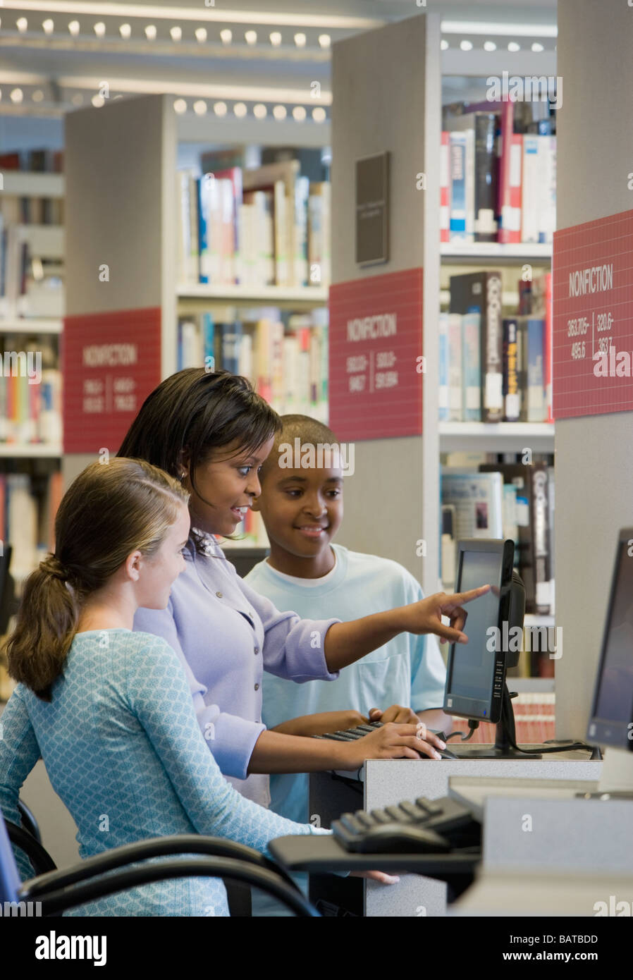 Teacher and students researching in library Stock Photo - Alamy
