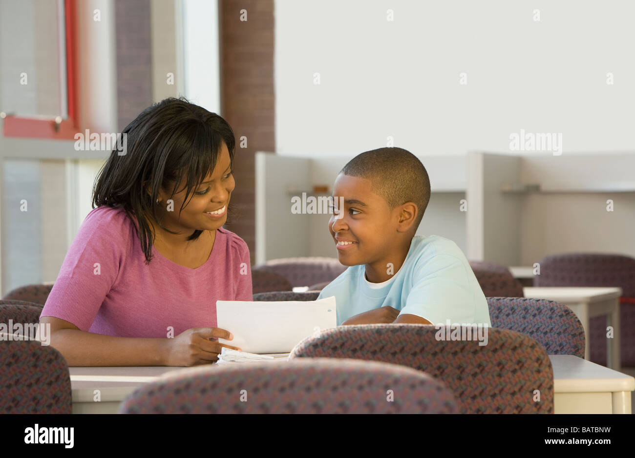 Teacher helping student with homework Stock Photo - Alamy