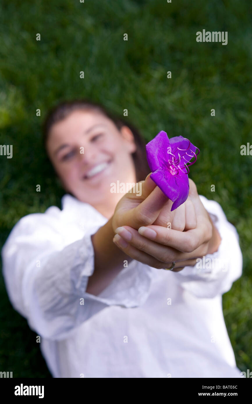 young woman lying down with purple flower Stock Photo - Alamy