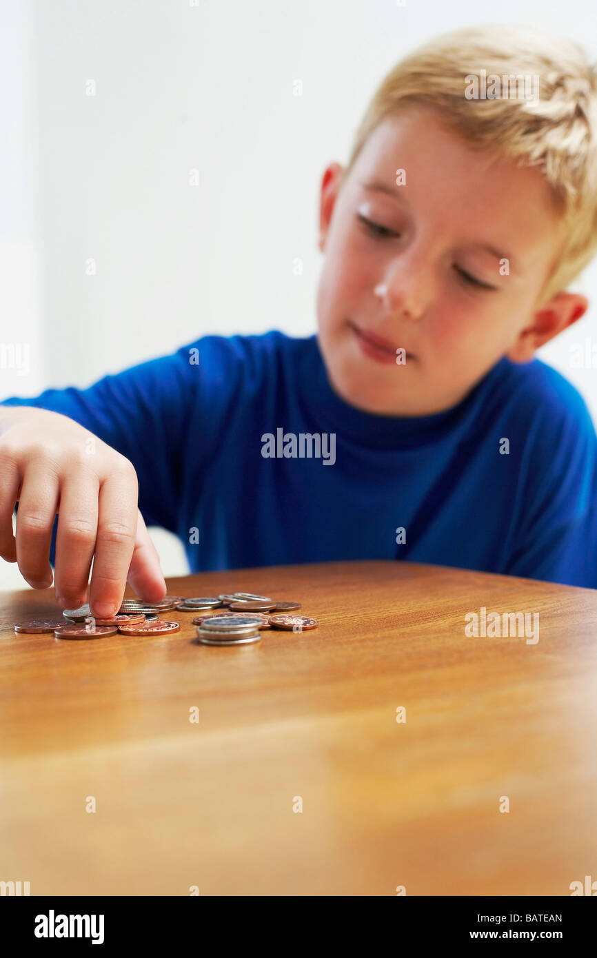 Child with loose change. Young boy saving money from an early age. He ...