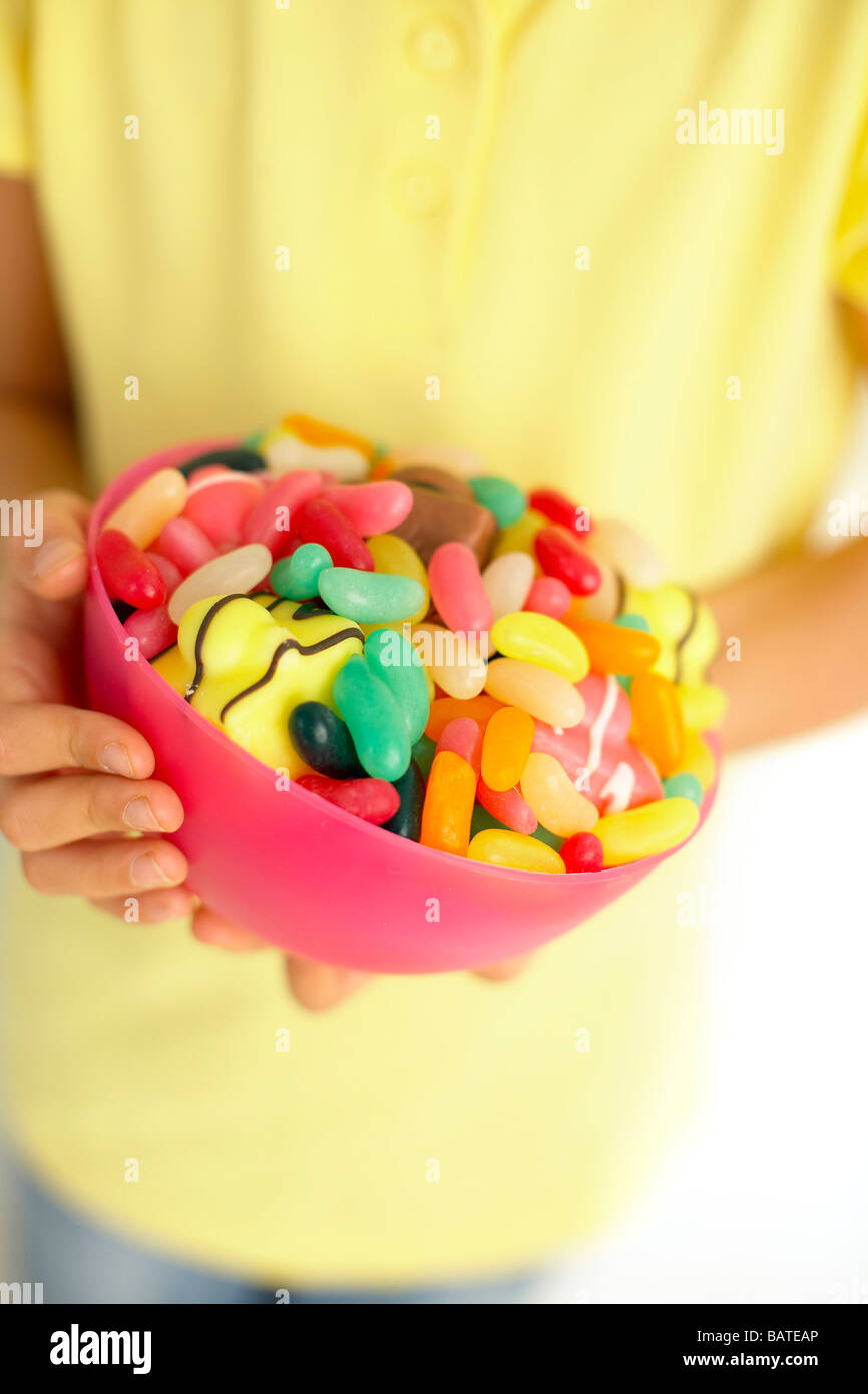 Bowl of sweets in a child's hands Stock Photo - Alamy