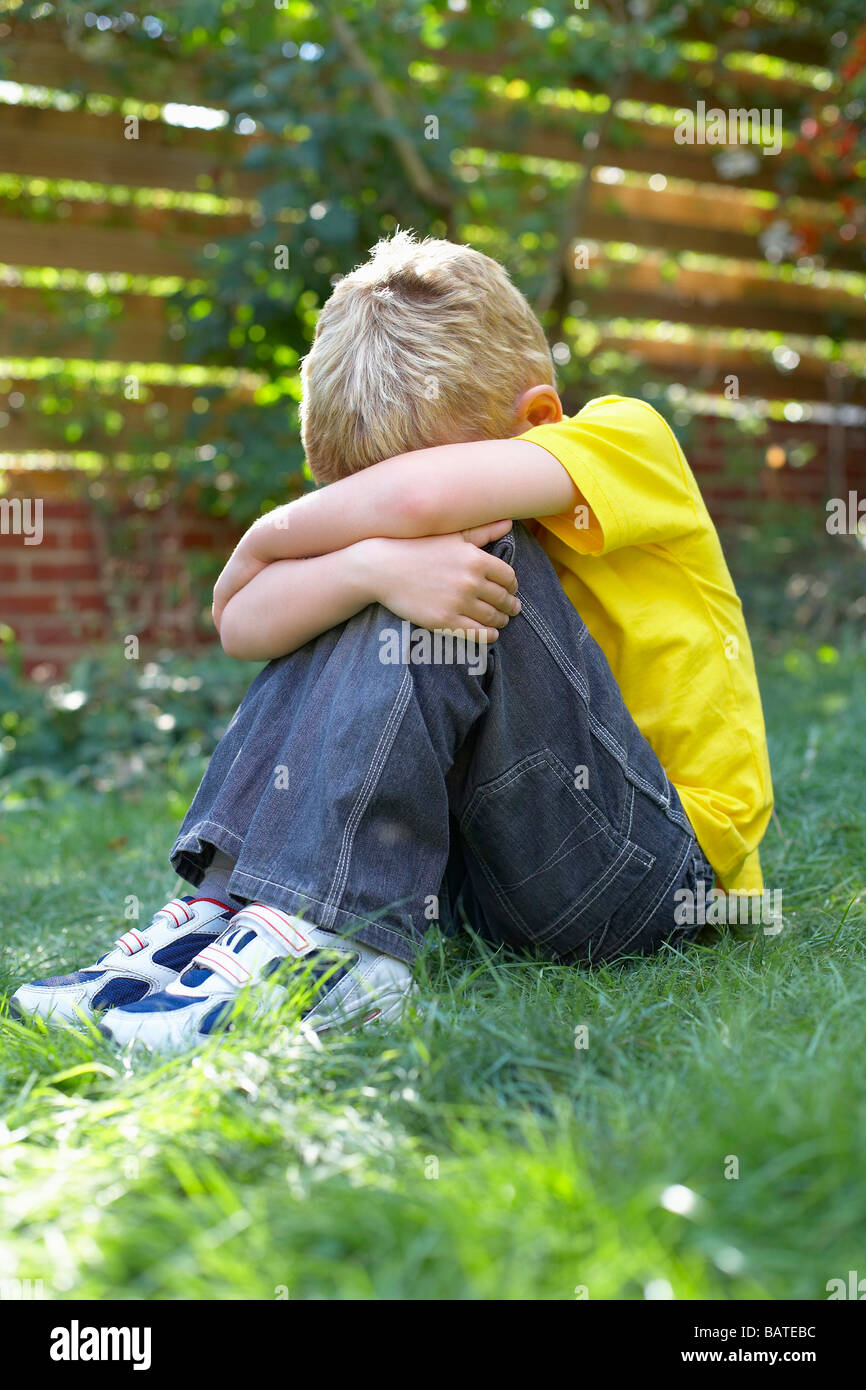 Unhappy boy crying in his garden. He is six years old Stock Photo - Alamy