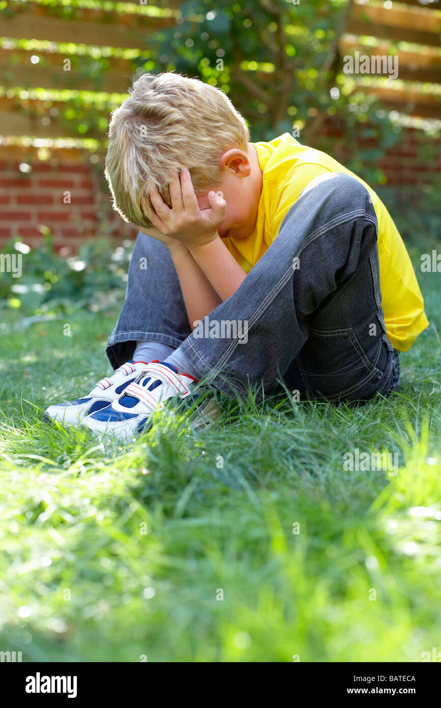 Unhappy boy crying in his garden. He is six years old Stock Photo - Alamy