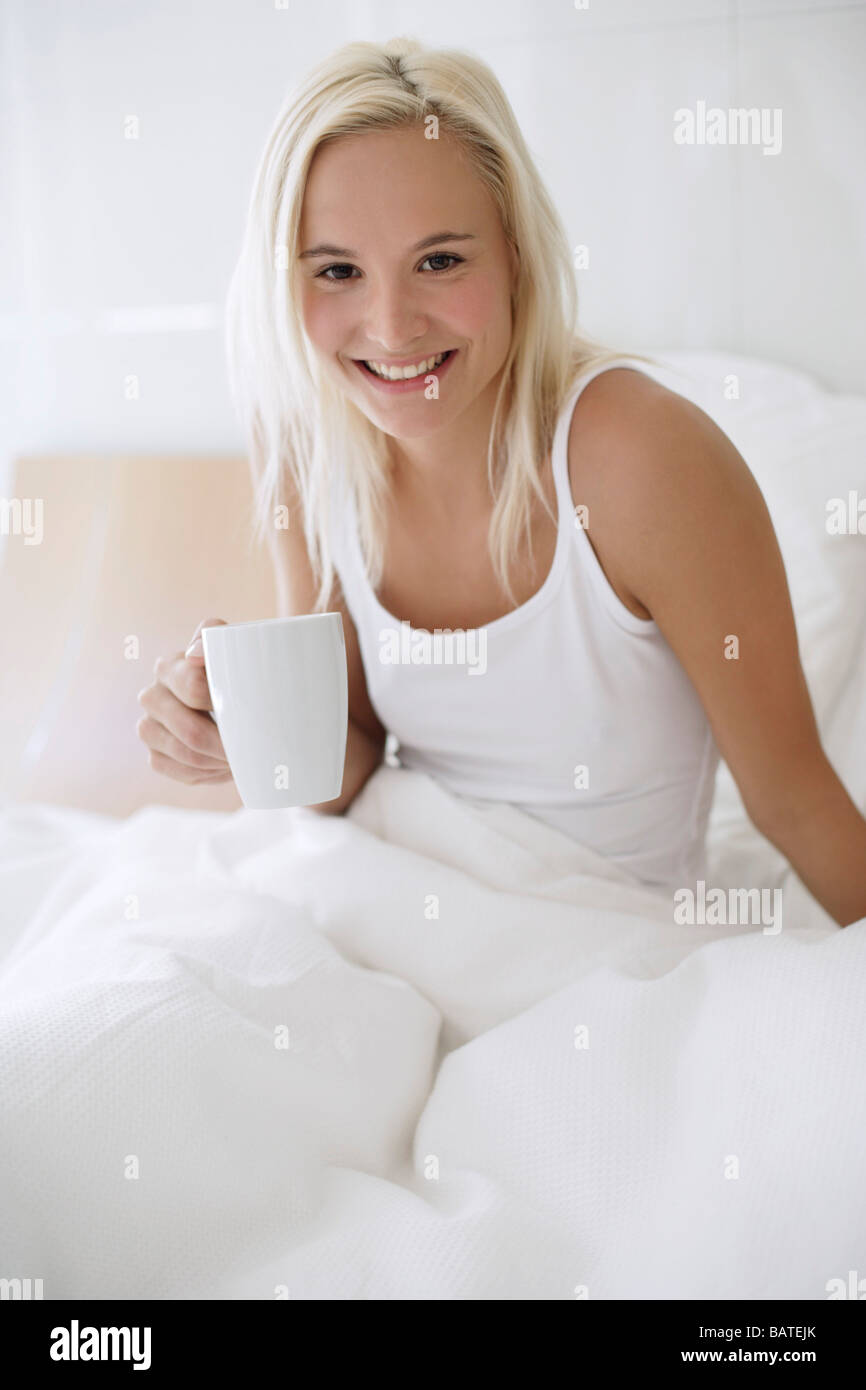 Woman drinking tea in bed after waking Stock Photo - Alamy