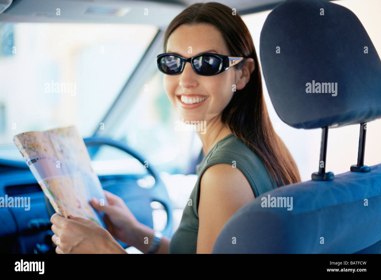 Road navigation. Woman driverholding a road map Stock Photo - Alamy