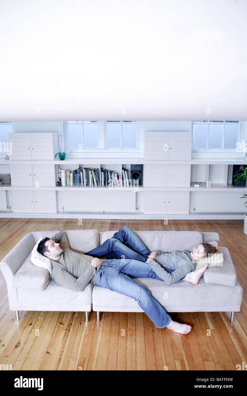Relaxed couple sleeping on sofa hi-res stock photography and images - Alamy