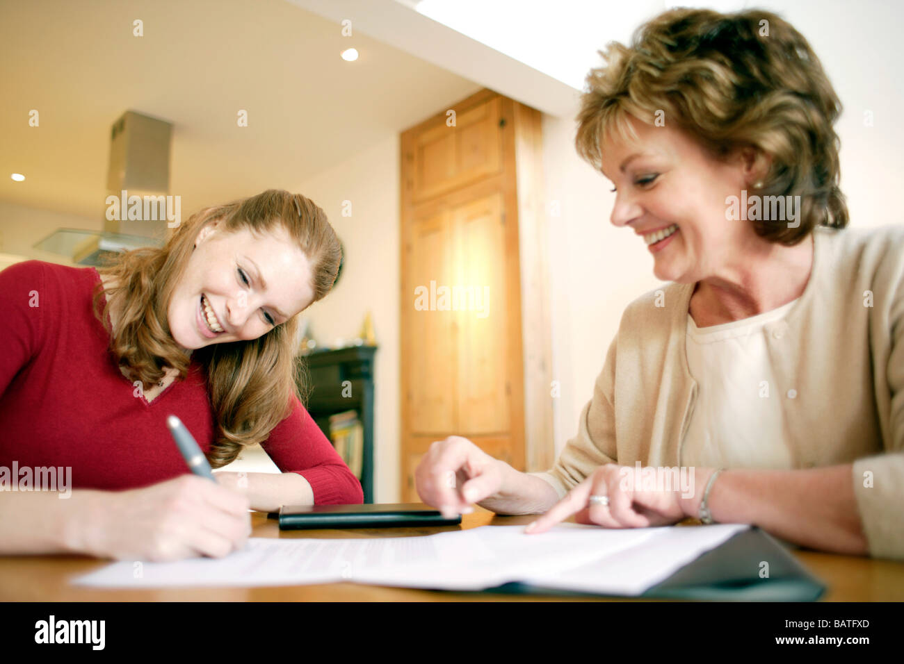 Mother and daughter. Daughter signing forms Stock Photo - Alamy