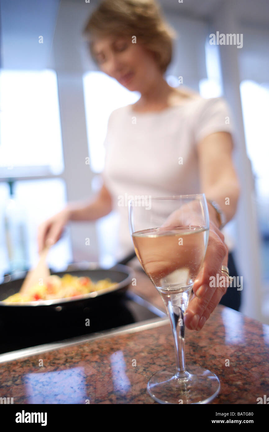Woman cooking in a kitchen with a glass of wine Stock Photo - Alamy