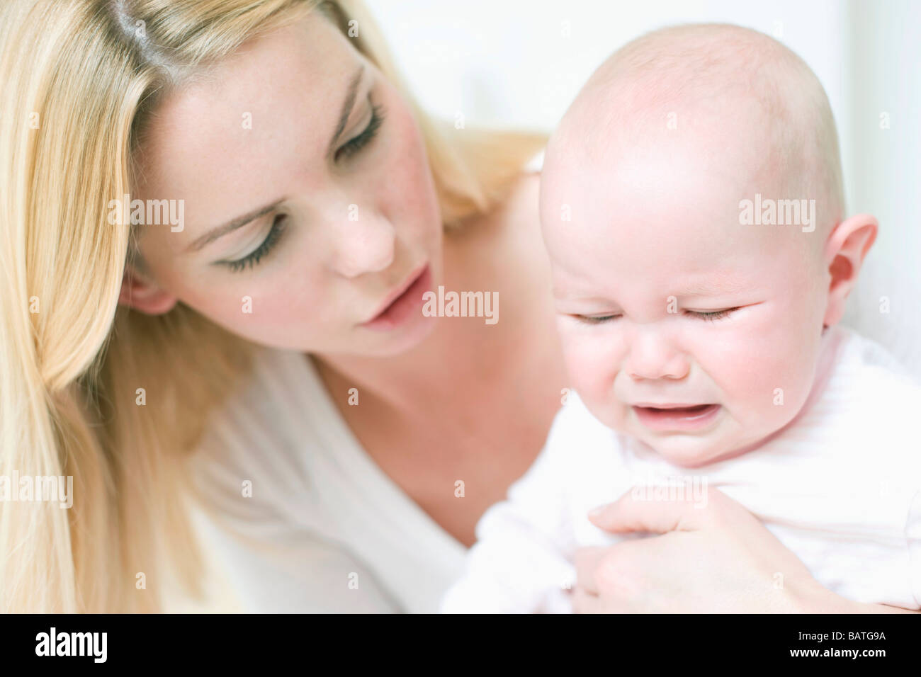 Unhappy baby. 7 month old babygirl being comforted by her mother Stock ...