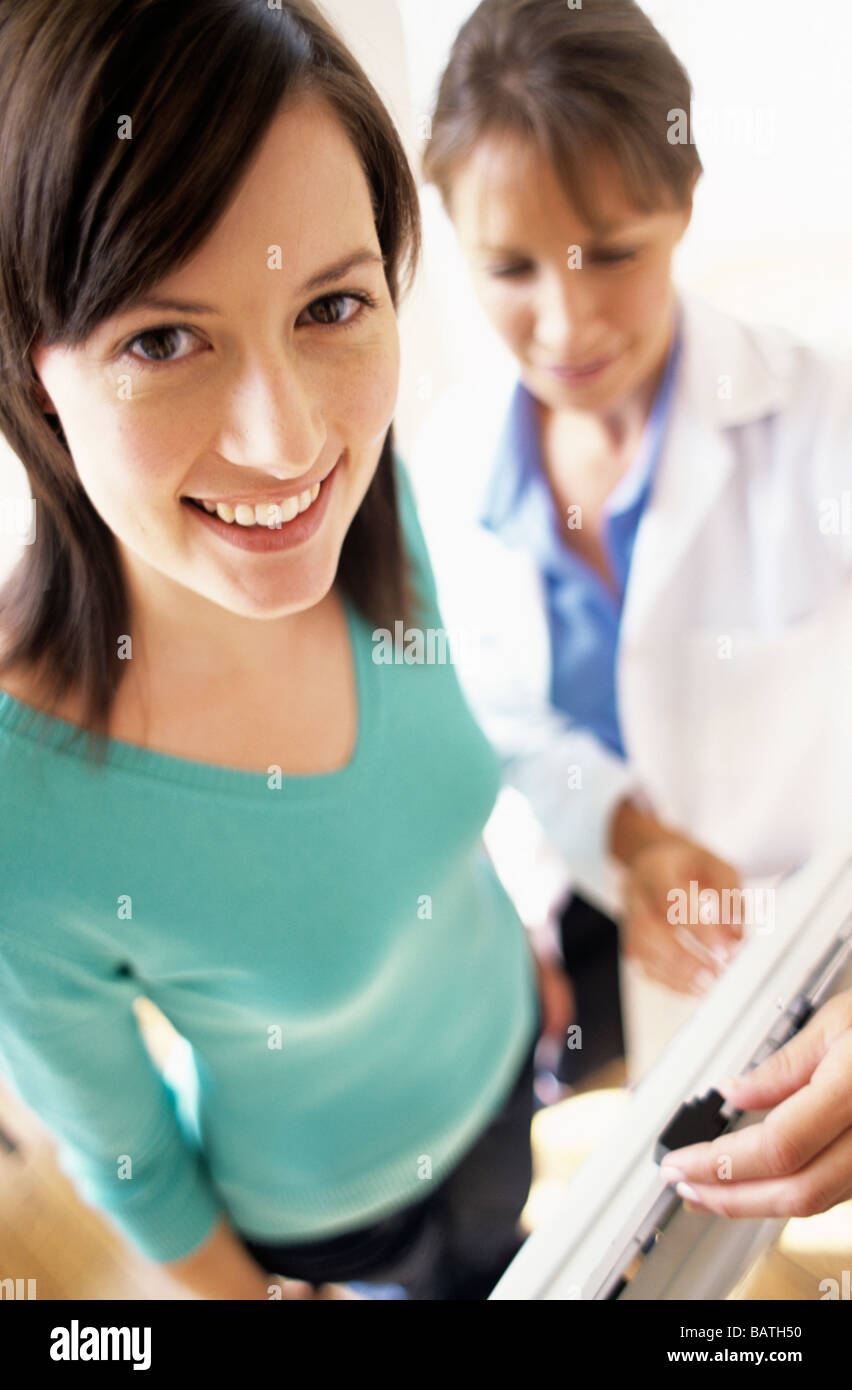 Weight check-up. General practice doctor adjusting the balance on ...