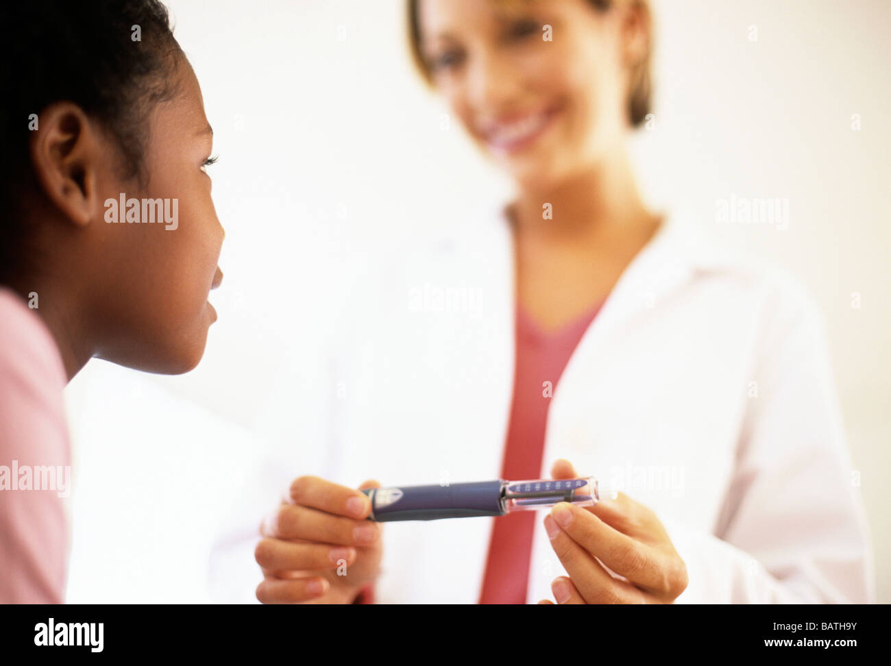 Insulin syringe. Diabetic 9 year old girl listening to her doctor ...
