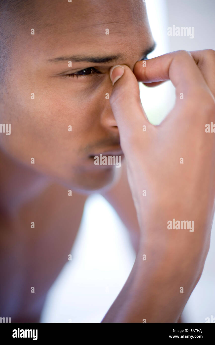 Sinus pain. Man holding the bridge of his nose in pain Stock Photo - Alamy
