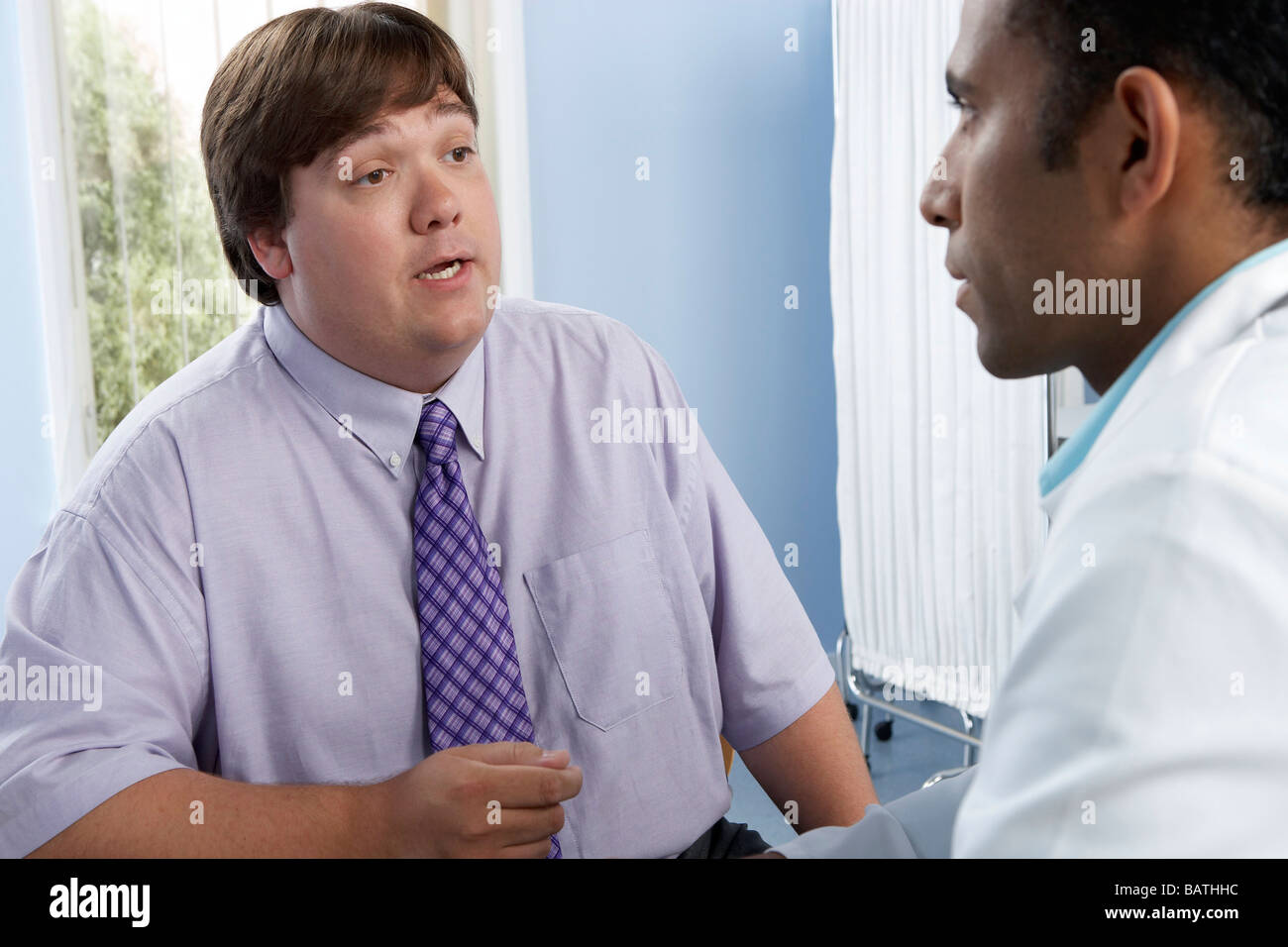 Consultation. Overweight manconsulting his doctor. Being overweight is ...