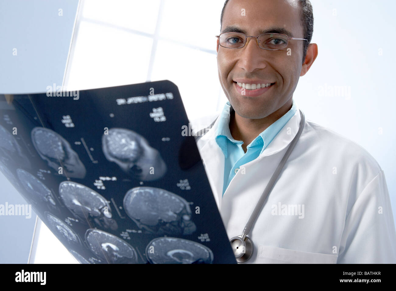 Doctor holding MRI scans. The scans are sagittal (vertical and sideways ...
