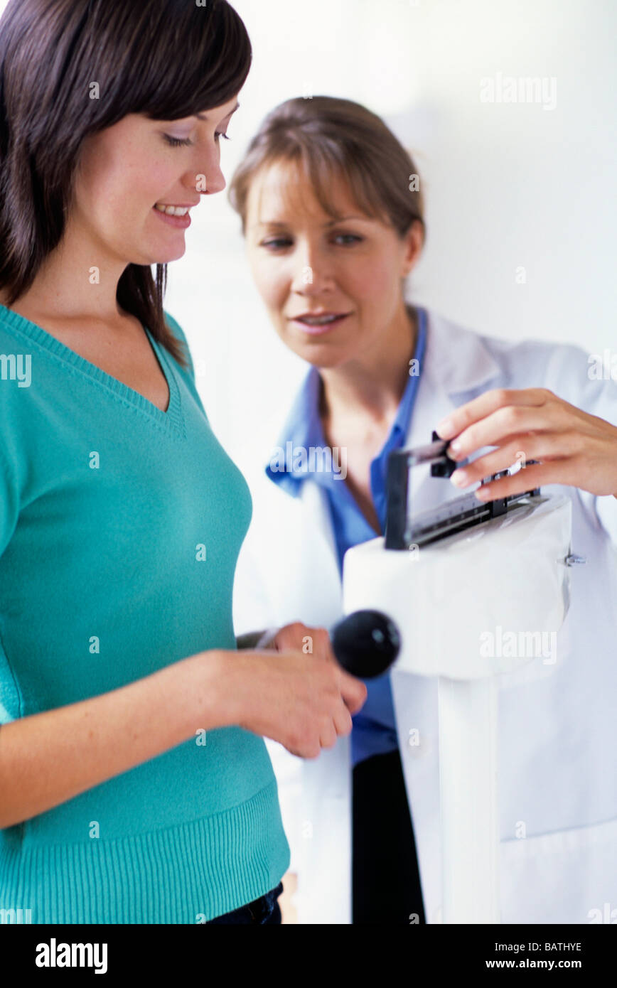 Weight check-up. Generalpractice doctor adjusting the balance on ...