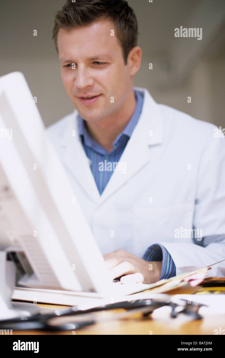 Doctor typing notes on acomputer in his office Stock Photo - Alamy