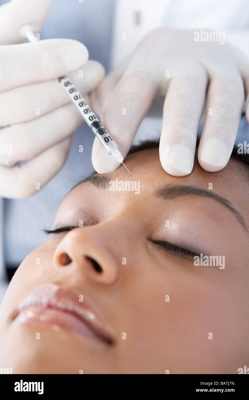 Botox treatment. Patient having botox injected into her face. Botox is ...