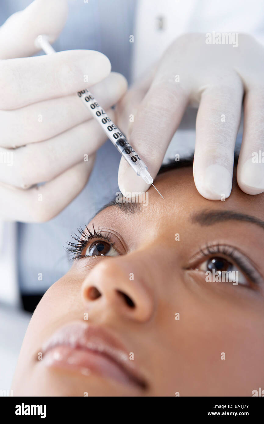 Botox treatment. Patient having botox injected into her face. Botox is ...