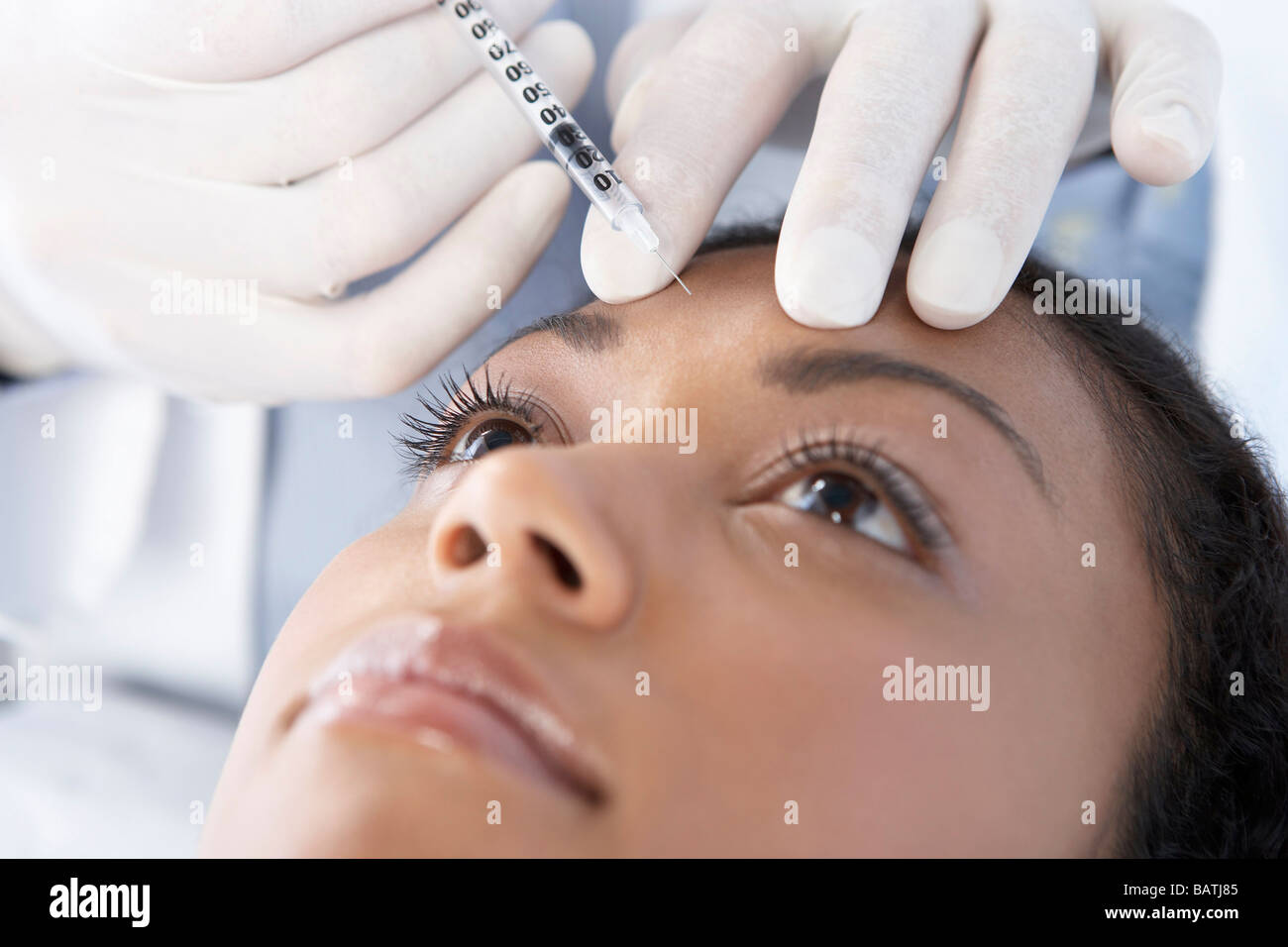 Botox treatment. Patient having botox injected into her face. Botox is ...