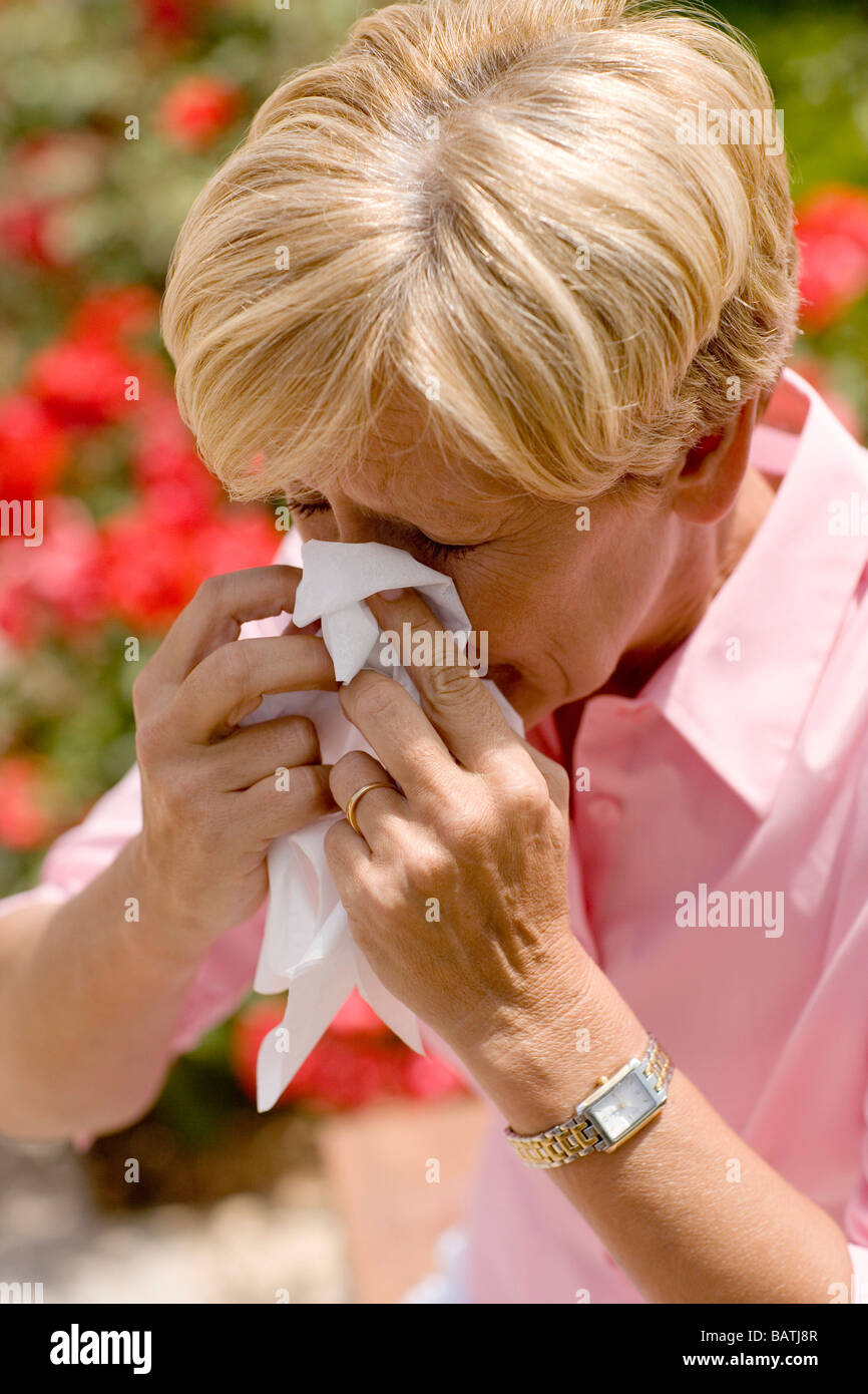 Hay fever. Woman sneezing into a tissue Stock Photo - Alamy