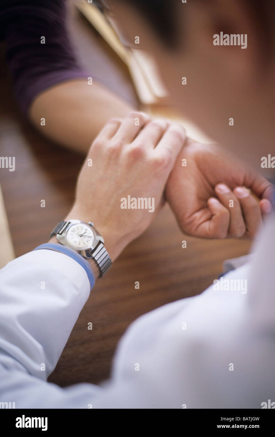 Pulse measurement. Generalpractice doctor measuring a patient's pulse ...