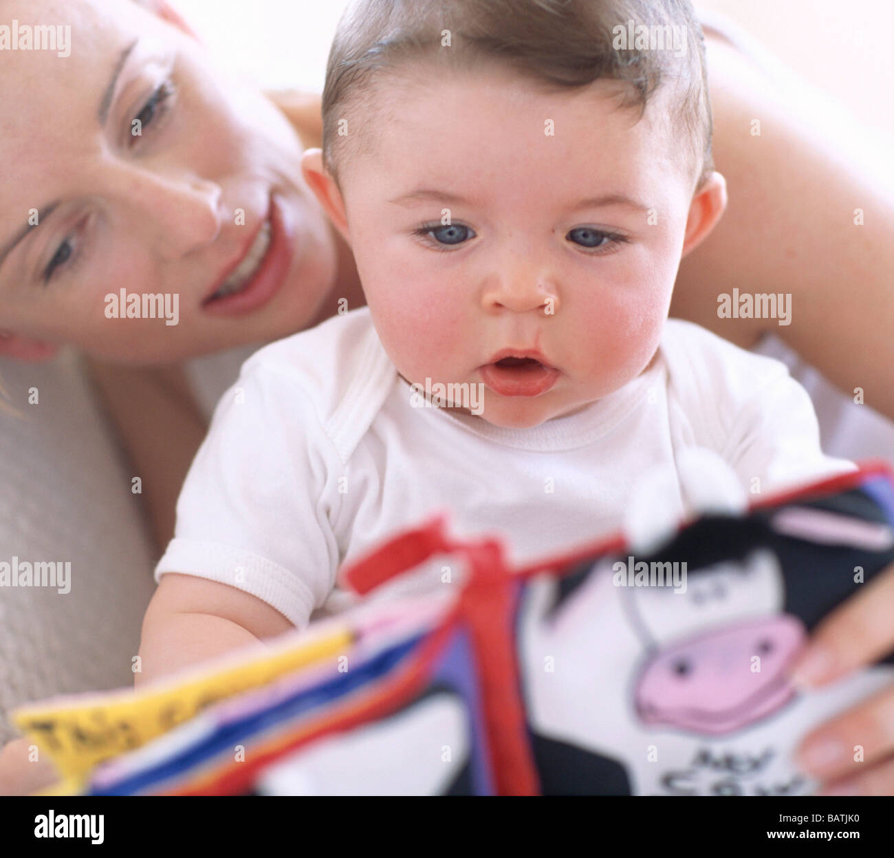 Mother reading to baby boy.Faces of a mother and her 6 monthsold baby ...