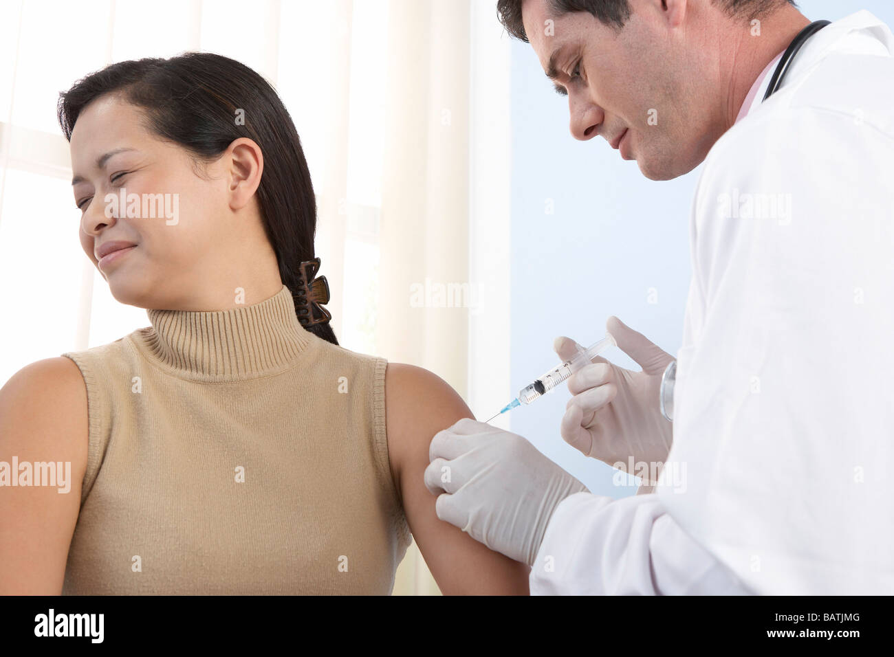 Doctor administering injection arm patient hi-res stock photography and ...