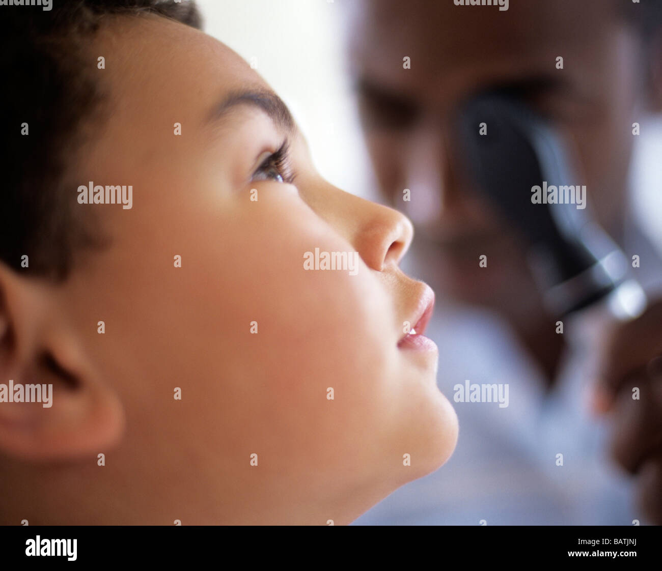 Eye examination. General practice doctor examining a 9-year-old boy eye ...