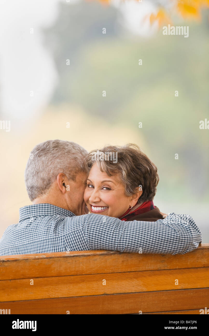 African couple hugging on park bench Stock Photo - Alamy