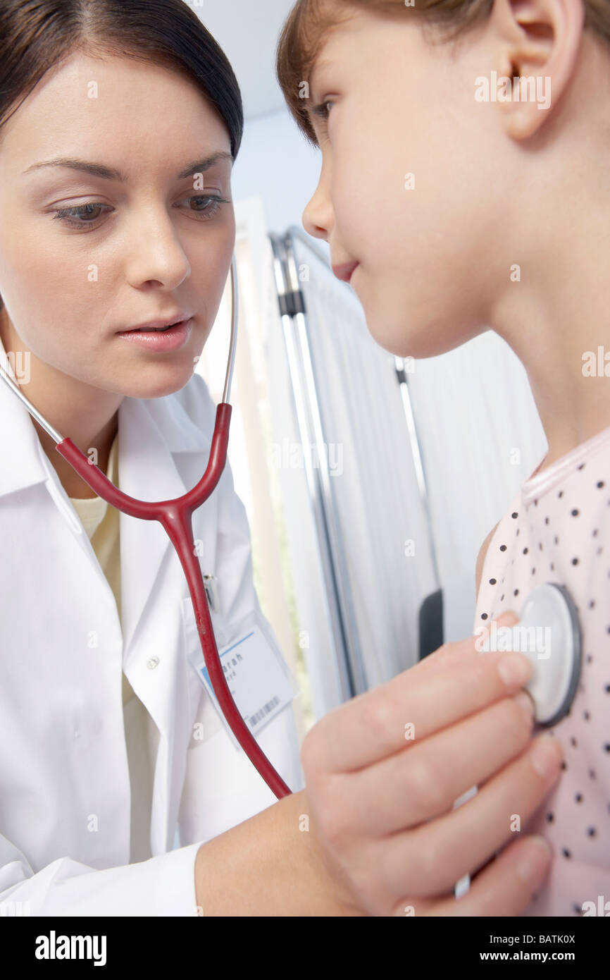 Paediatric examination. Doctor listening to a girl's chest sounds ...