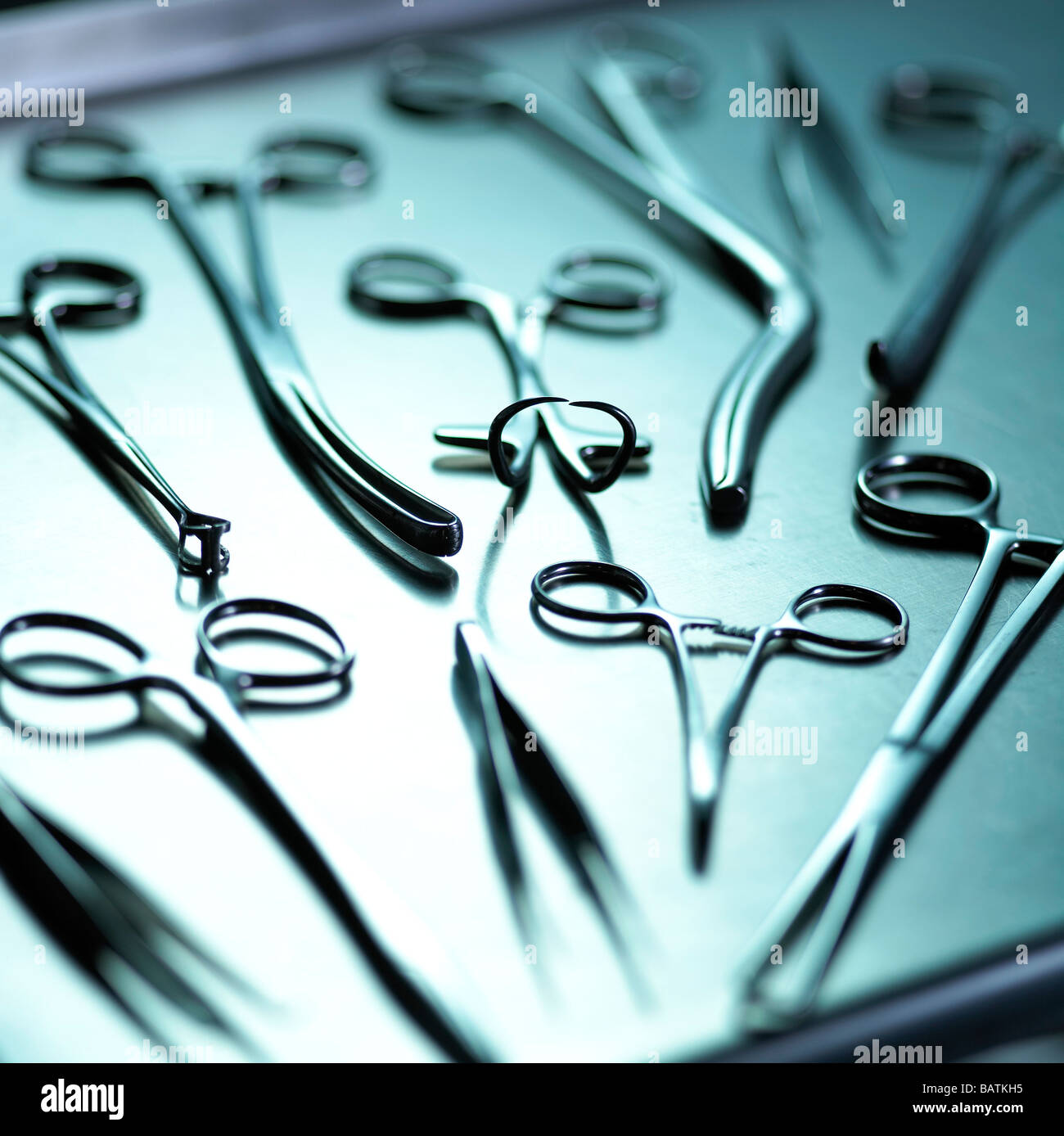 Surgical equipment. Metal forceps, tweezers and scissors on a tray ...