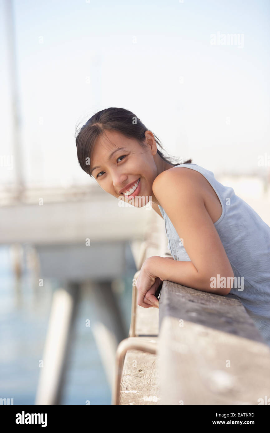 Asian woman leaning on railing Stock Photo - Alamy