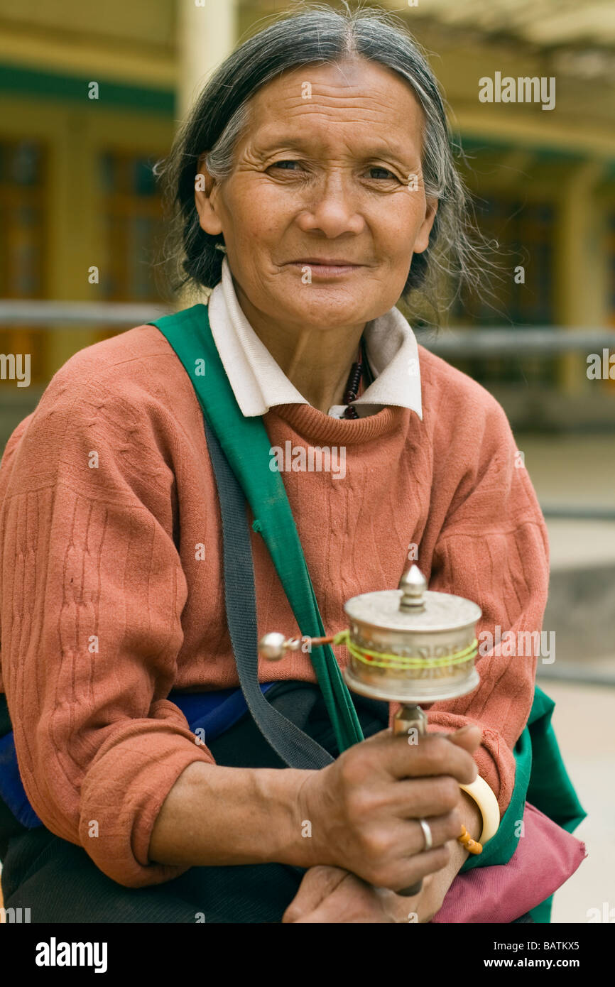 Portrait of an elder Tibetan Buddhist woman with her prayer wheel in ...