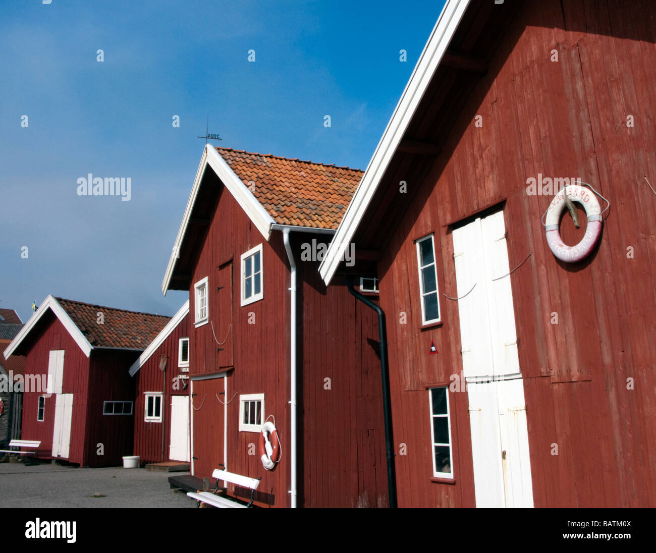 Traditional red wooden buildings beside harbour at Grundsund village on ...