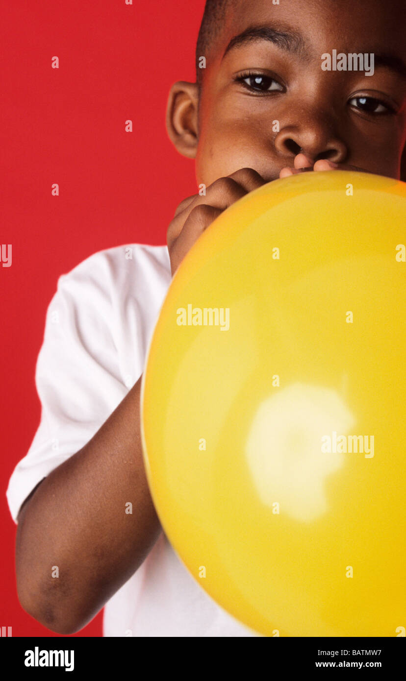 Blowing up a balloon. 6-year-old boy blowing up a yellow balloon Stock ...