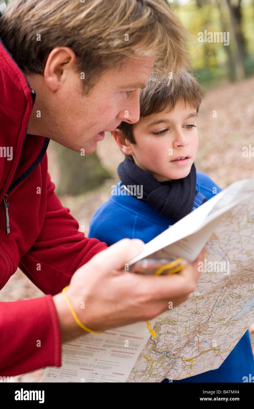 Father and son reading a map.The father is holding a compass in his ...