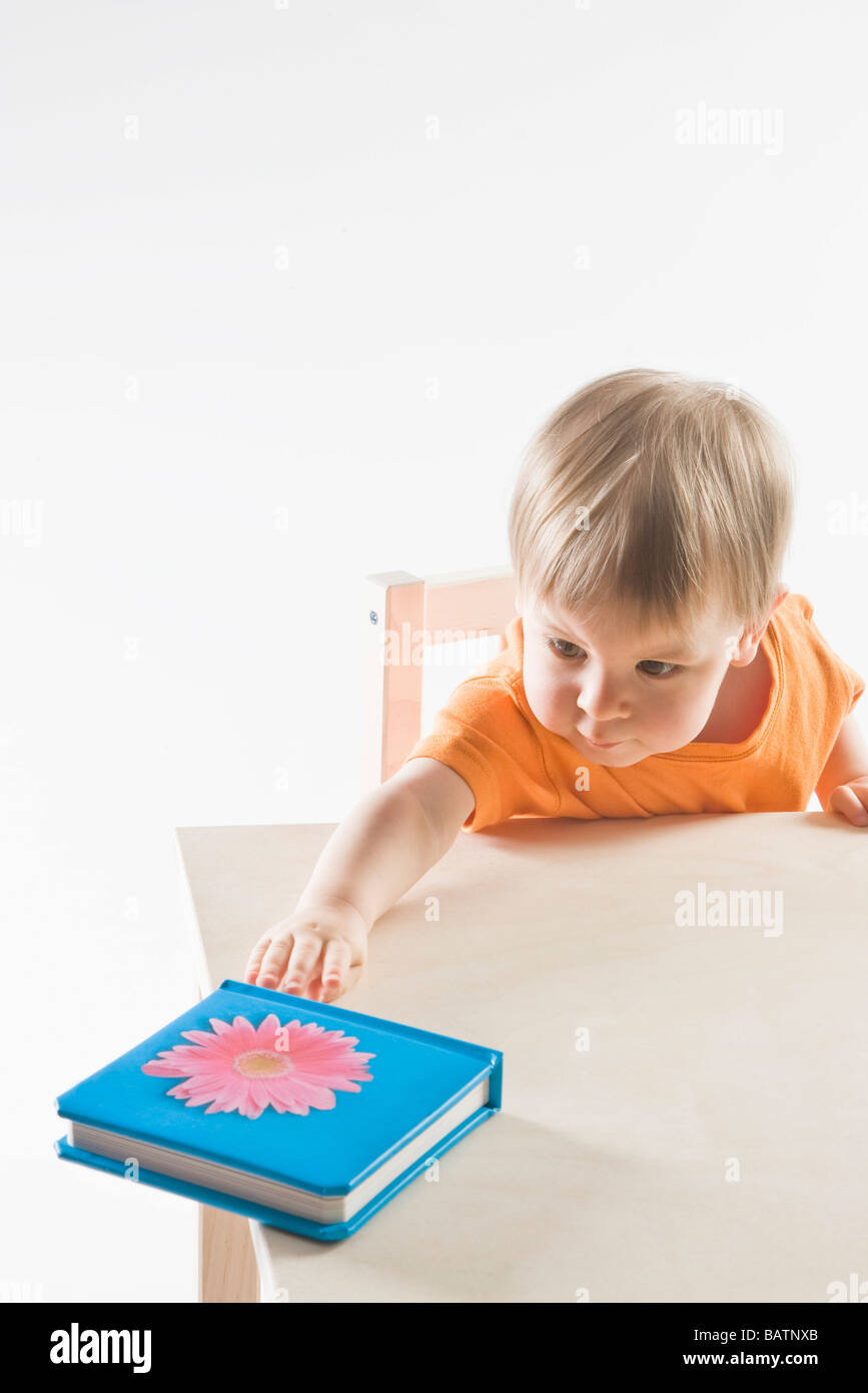 baby boy taking book Stock Photo - Alamy