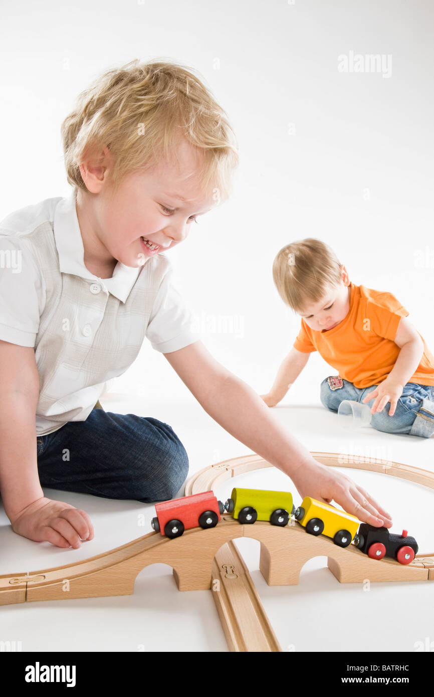 toddler boys playing with train set Stock Photo - Alamy