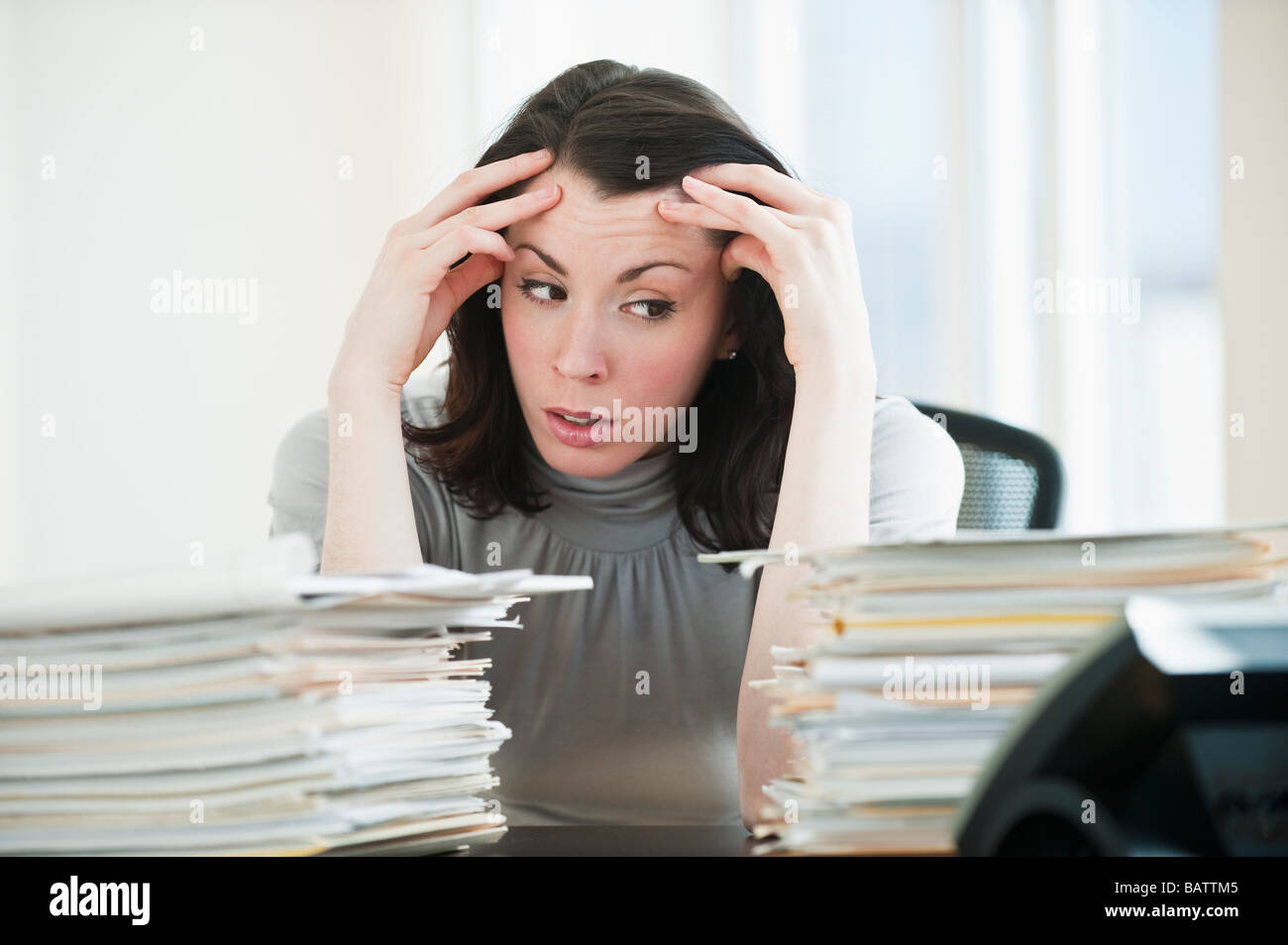 Stressed business woman observing paperwork in office Stock Photo - Alamy