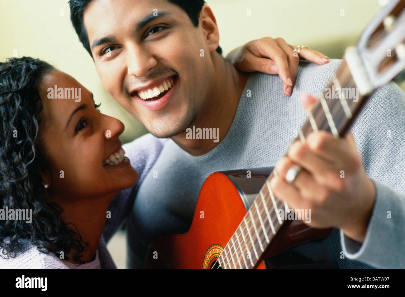 Hispanic couple with guitar hugging Stock Photo - Alamy