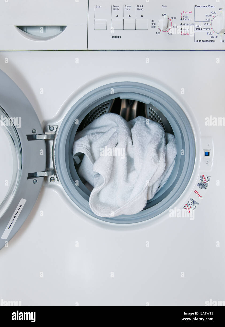 Washing machine with laundry sticking out, close-up Stock Photo - Alamy