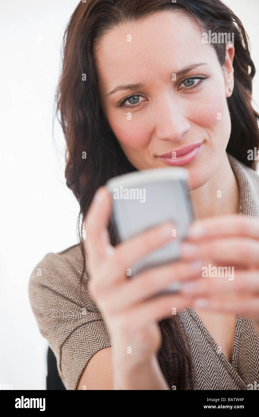 Woman using palmtop, smiling Stock Photo - Alamy