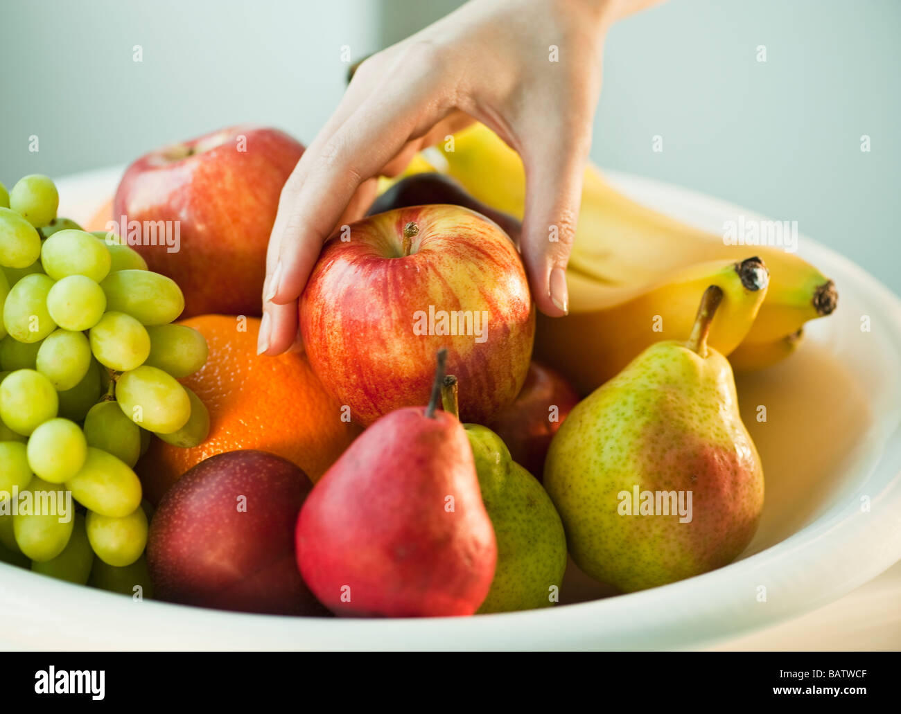 Woman's hand taking apple from fruit bowl Stock Photo - Alamy