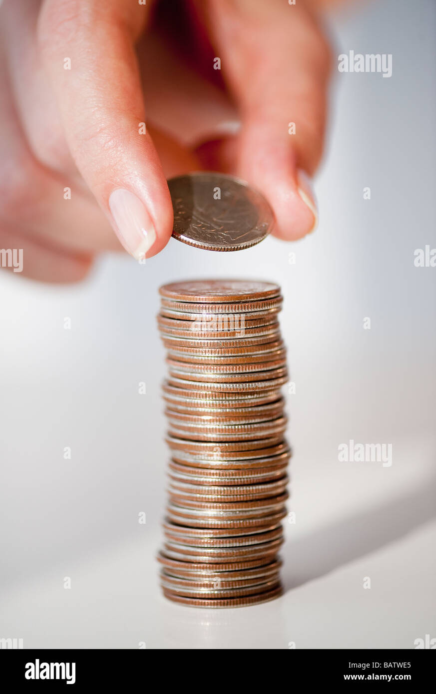 Close-up of woman's hand stacking coins Stock Photo - Alamy