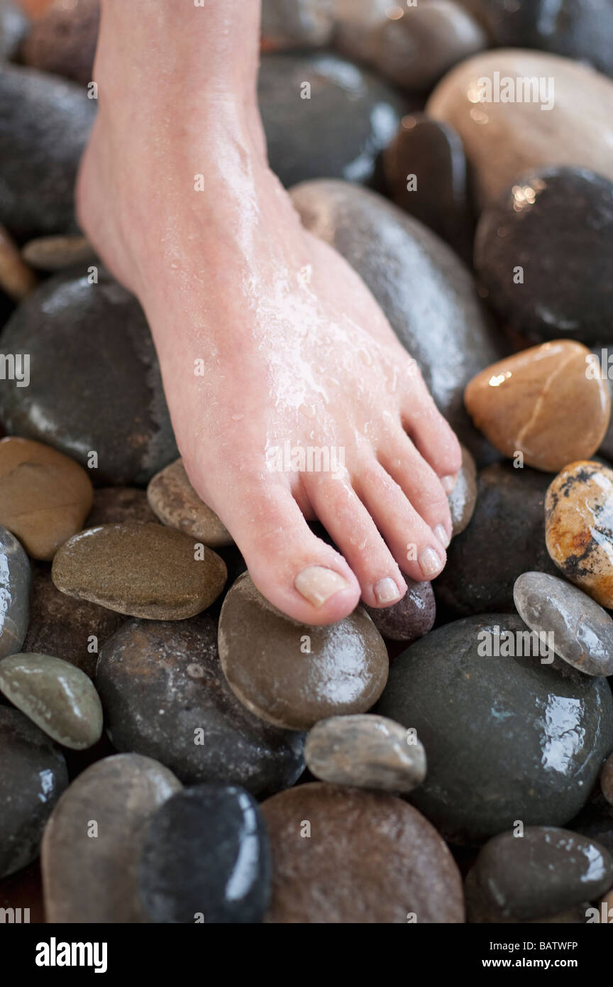 Close-up of woman's foot on pebbles Stock Photo - Alamy