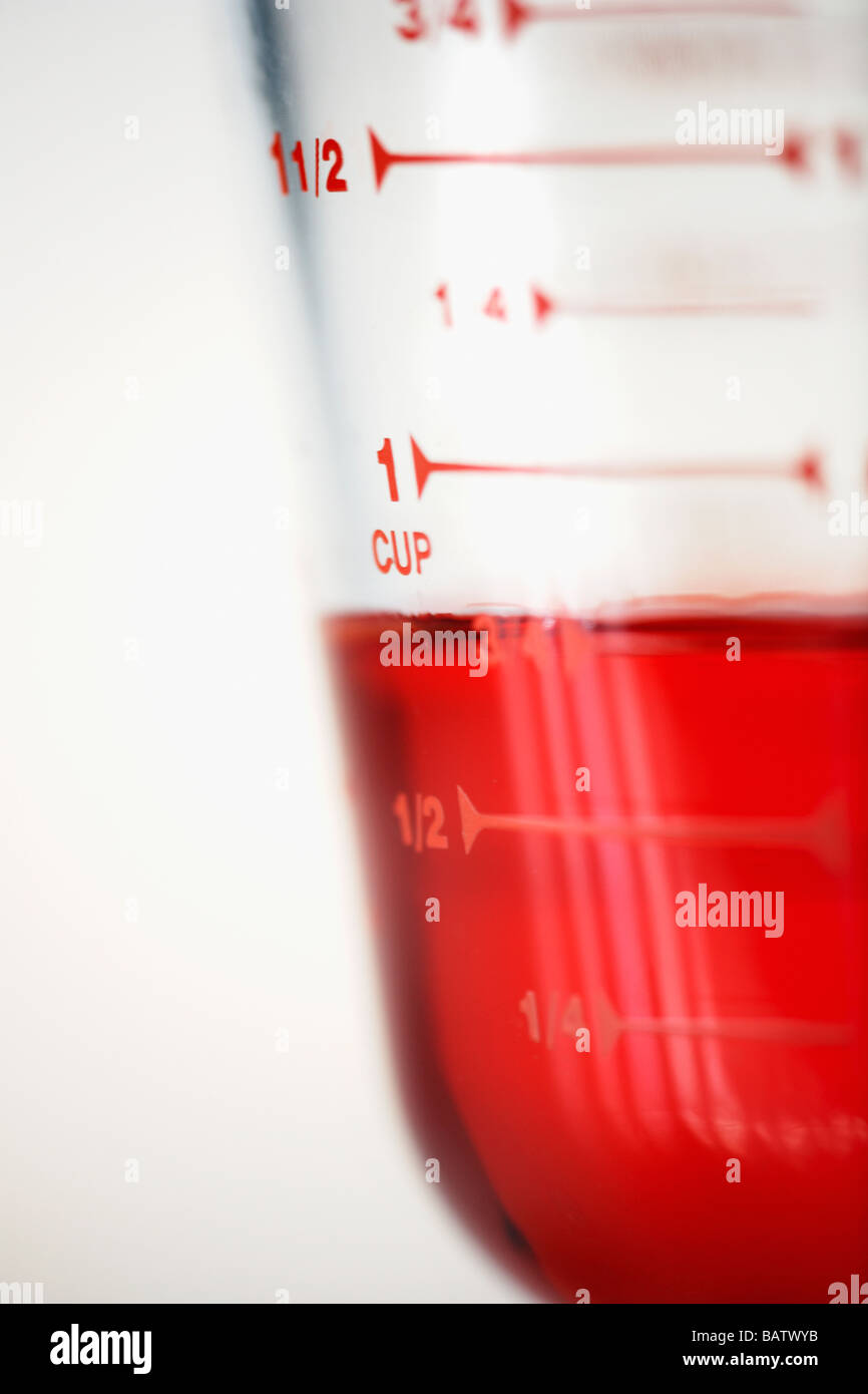 Measuring jug filled with red liquid, close-up Stock Photo - Alamy