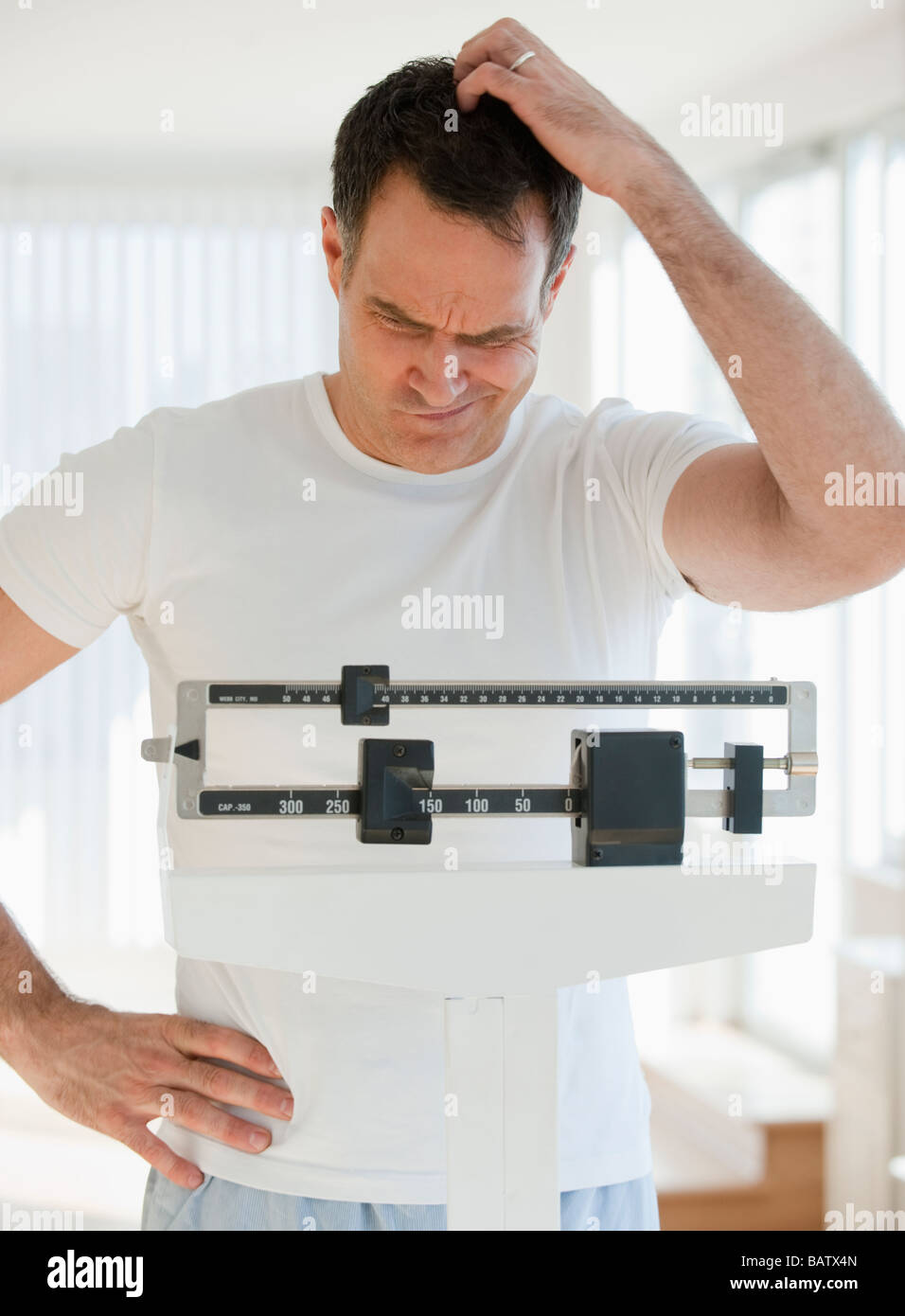 Mature man on scales Stock Photo - Alamy