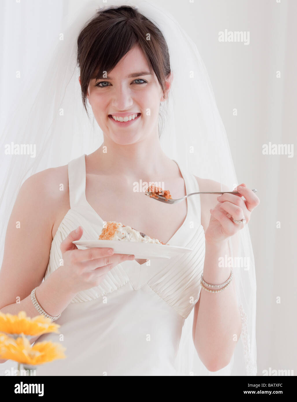 Portrait of bride eating wedding cake Stock Photo - Alamy