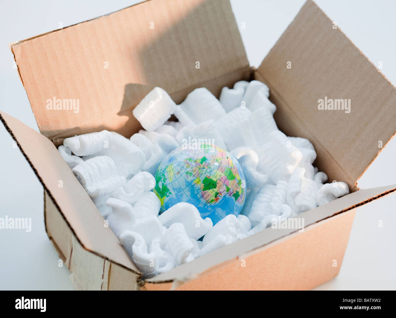 Globe in cardboard box with packing peanuts Stock Photo - Alamy