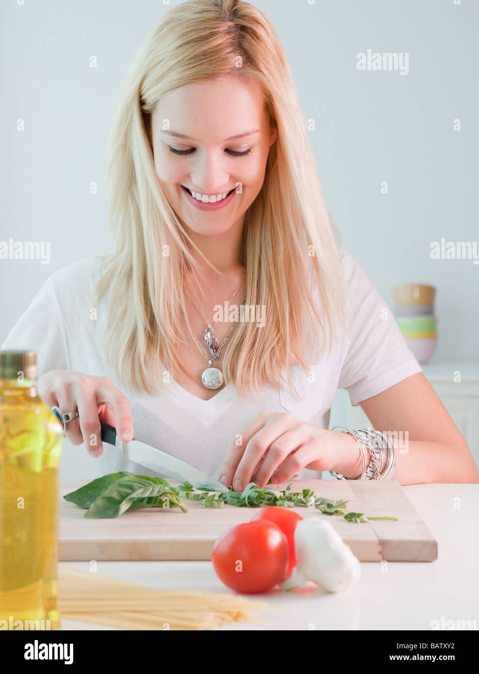 Young woman chopping basil Stock Photo - Alamy